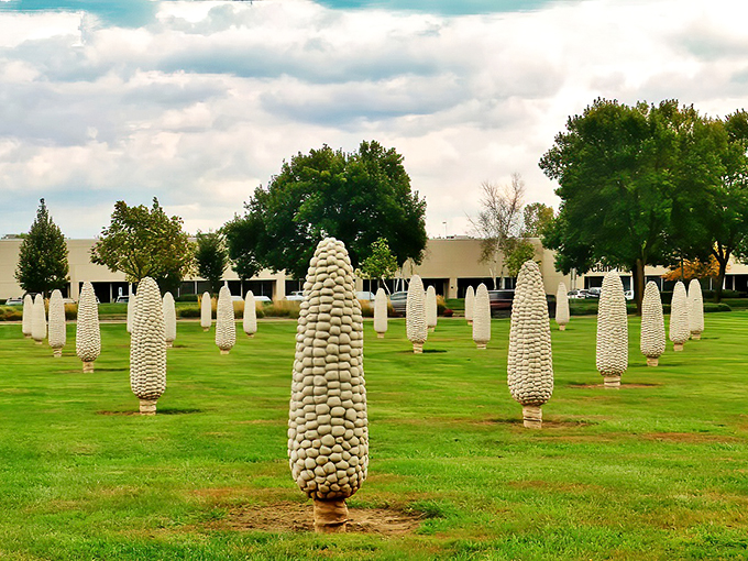 "Honey, I shrunk the humans!" A surreal landscape of towering corn sculptures stands sentinel under a brilliant blue sky.