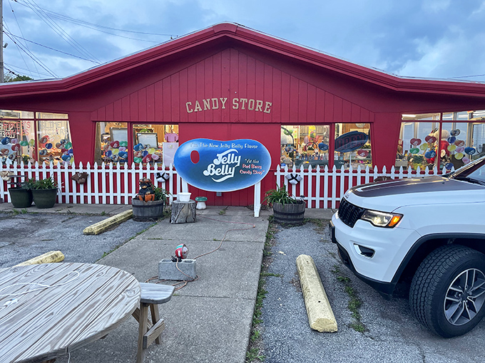 A candy-coated dream come true! This vibrant red building isn't just a shop; it's a portal to childhood joy, complete with a picket fence to hold back the sweetness.