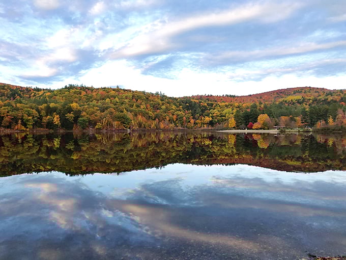 Mirror, mirror on the lake! Echo Lake's glassy surface reflects autumn's fiery palette, creating a double dose of Vermont's fall splendor. Nature's own Rorschach test, wouldn't you say?