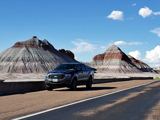 Road trip through time: Where modern wheels meet ancient hills in the Painted Desert of Petrified Forest National Park.
