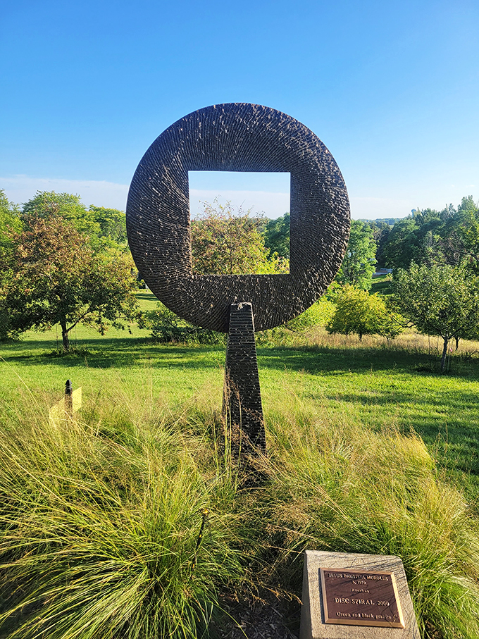 Art meets nature in this mesmerizing sculpture. It's like a window to another dimension, right in the garden.