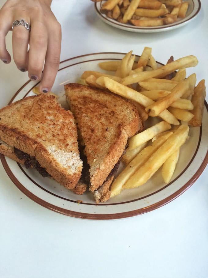 Melty magnificence! This patty melt is the stuff of greasy spoon dreams, flanked by an army of golden fries ready for battle.
