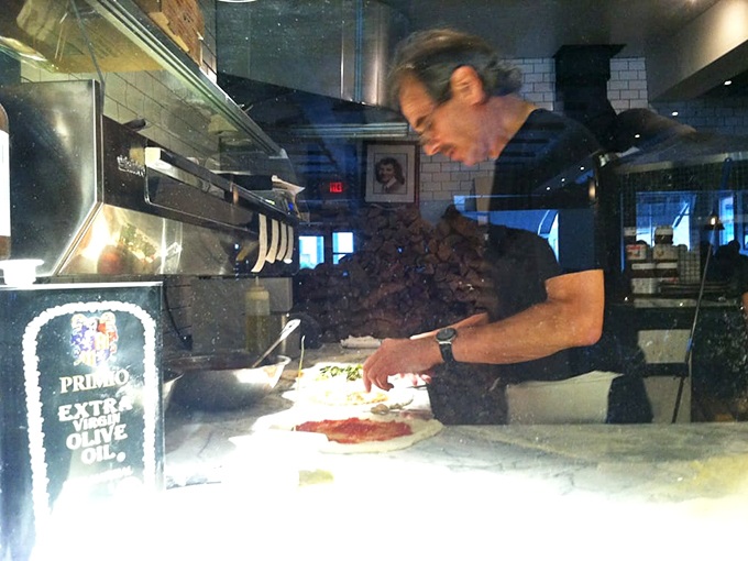 Witness the pizza whisperer at work! This maestro of mozzarella is crafting edible masterpieces faster than you can say "extra cheese, please!"