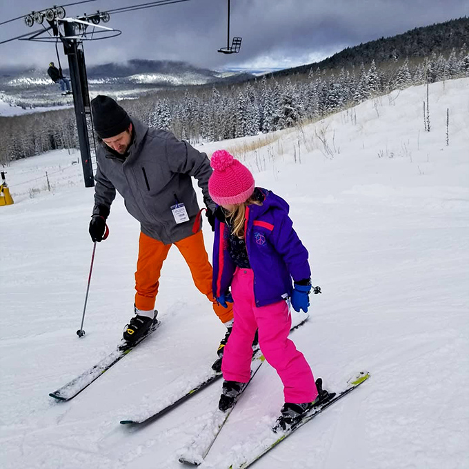 Passing on ski wisdom like a cherished family recipe. This heartwarming scene of intergenerational bonding on the slopes is sweeter than hot cocoa by the fire.