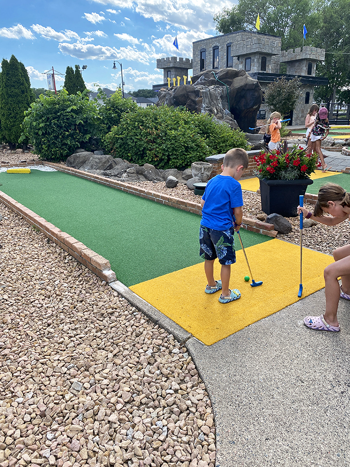 Future pro or first-time putter? At Lilli Putt, everyone's a champion. This young golfer's determined face says it all - mini-golf is serious business!