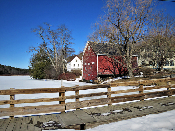 Winter transforms the scene into a snow globe come to life, with the red barn adding a perfect pop of color.