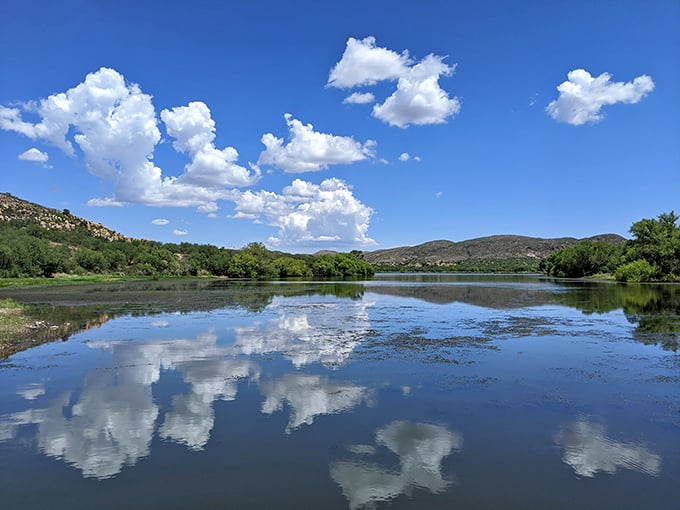 Nature's mirror: Fluffy clouds paint a perfect reflection on the tranquil waters.