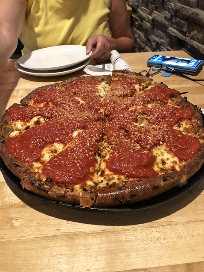 Behold the deep-dish delight! This pizza is deeper than a philosopher's thoughts and richer than a tech mogul. It's a cheesy, saucy treasure chest waiting to be explored.