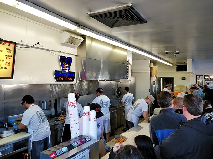 It's standing room only in this hot dog hotspot. The crowd's anticipation is thicker than the steam rising from the grill.