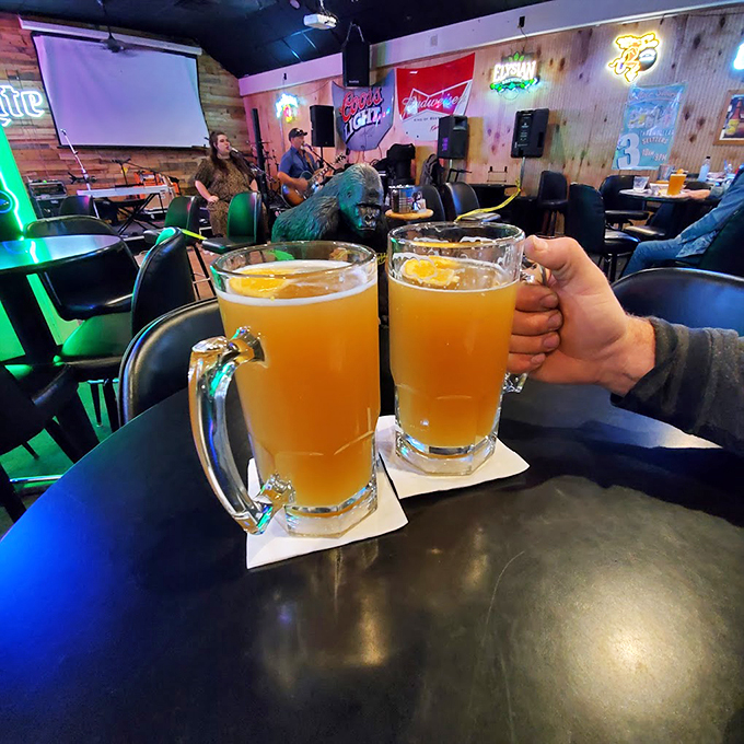 Cheers to good times! These frosty mugs are filled with liquid gold. In the background, live music sets the scene for a perfect night out.