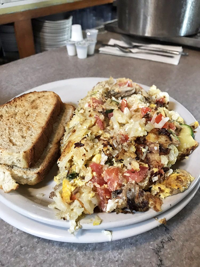 The infamous "Garbage Plate" in all its glory &ndash; a beautiful mess of eggs, veggies, and who-knows-what-else that's tastier than its name suggests.