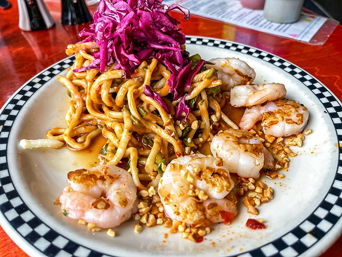 Shrimp on a holiday! These plump crustaceans are living it up on a bed of noodles, with a pop of purple slaw for good measure.