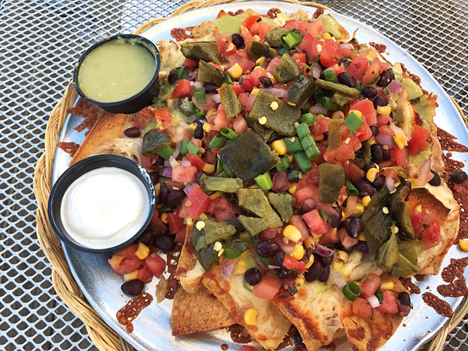 A fiesta on a plate! These nachos are piled so high with toppings, they're practically begging for their own area code.