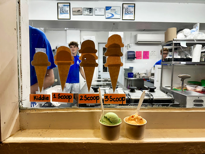 Behind the counter, ice cream alchemists work their magic. From kiddie cones to triple scoops, dreams come in all sizes here.