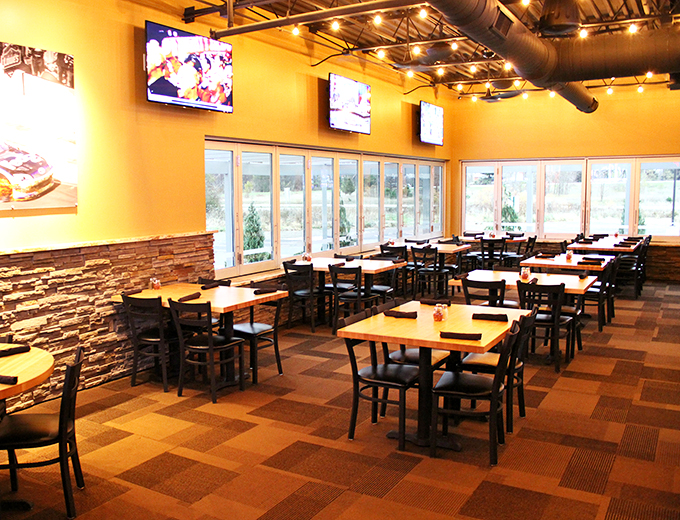 Step inside and feel the buzz! Klavon's interior is a golden-hued haven where the glow of TVs mingles with the aroma of melting cheese. It's like being inside a delicious sports highlight reel.