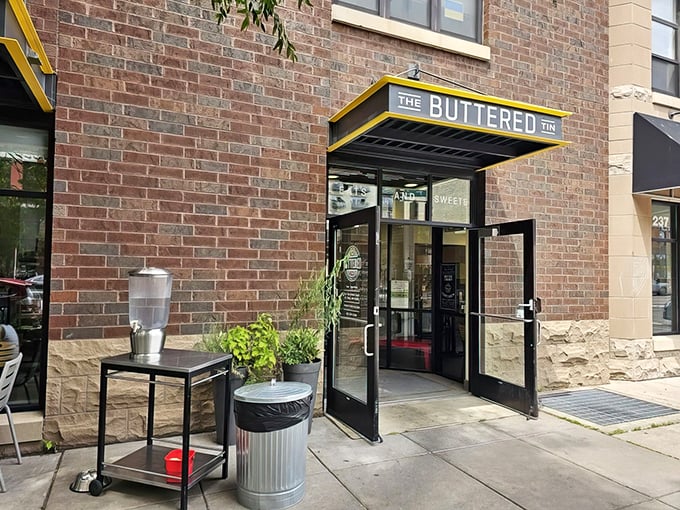 Brick, glass, and a promise of buttery goodness. The Buttered Tin's entrance is like a portal to flavor town.