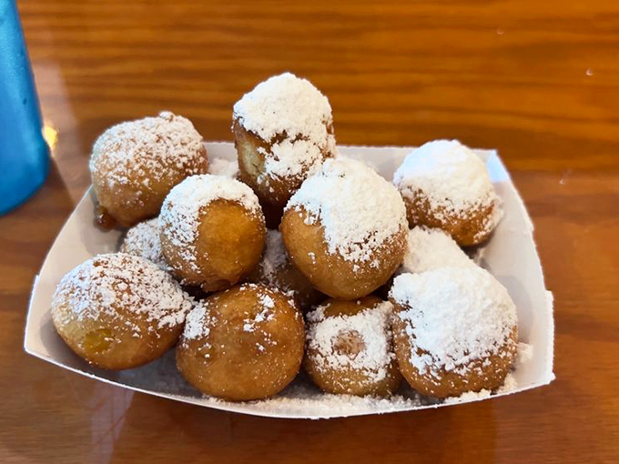 Behold, the corn fritter crown jewels! These golden nuggets of joy are like edible sunshine, dusted with powdered sugar snow.
