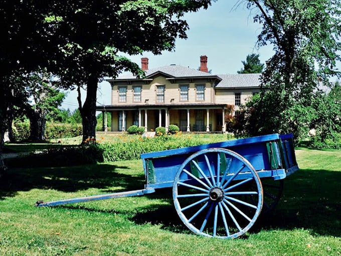 Giddy up! Nothing says "19th-century charm" quite like a bright blue horse-drawn carriage parked in front of a stately mansion.