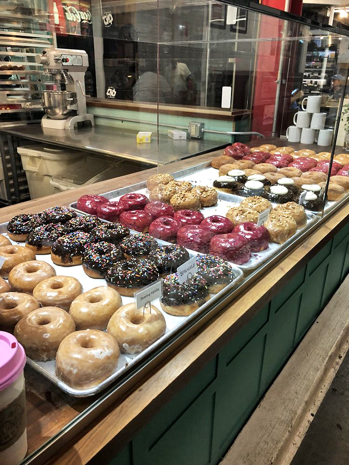 A rainbow of rings to rule them all! This donut display case is like the jewelry counter at Tiffany's – if Tiffany's sold edible, frosted treasures.
