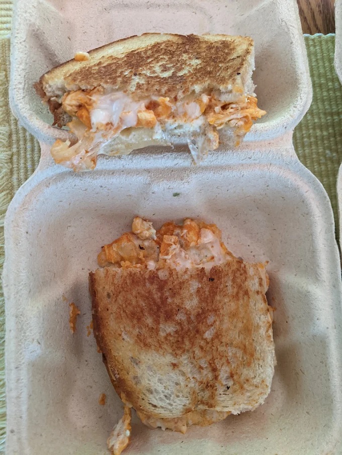 Look at that cheese pull! The buffalo chicken melt reveals its gooey soul in this mouthwatering cross-section shot.