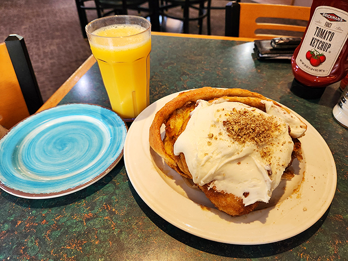 Holy cinnamon, Batman! This isn't just a roll, it's a pastry skyscraper. Topped with a snowfall of icing, it's the breakfast of champions (and possibly small armies).