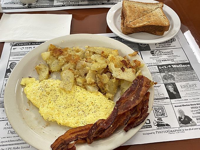 The breakfast trifecta: golden eggs, crispy potatoes, and bacon that could make even vegans question their life choices.
