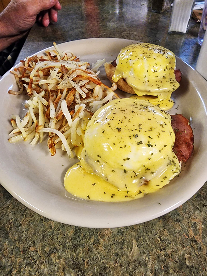 Eggs Benedict, reimagined! Golden hollandaise cascades over perfectly poached eggs, promising a breakfast worthy of royalty (or at least a very happy you).