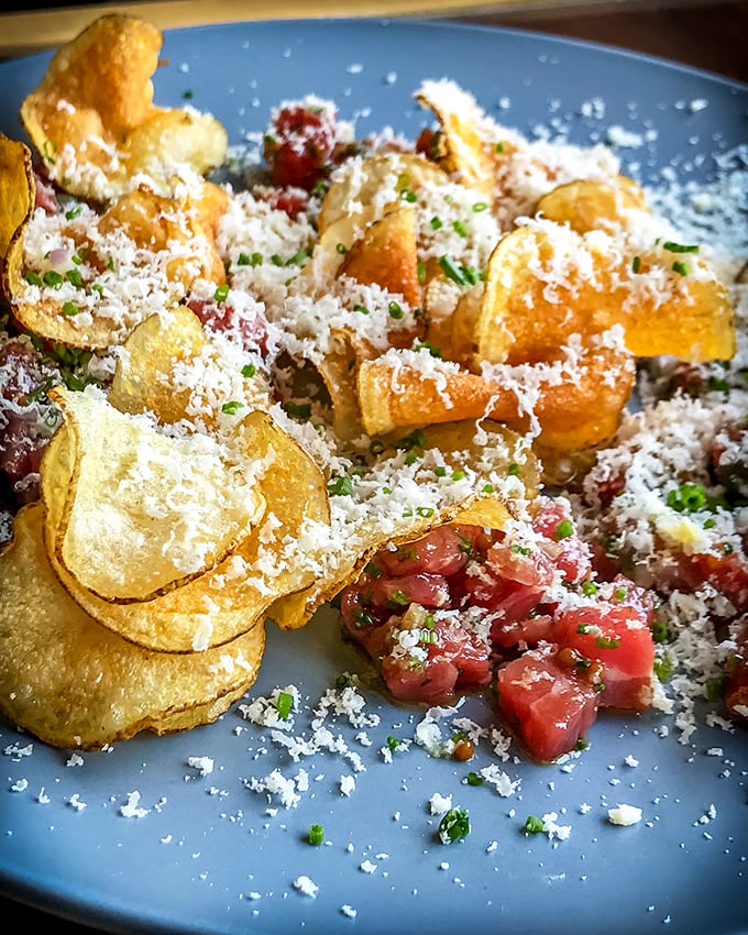 Steak tartare that's dressed to impress! It's like a tiny meat tuxedo, ready to dance across your taste buds with its crispy chip entourage.
