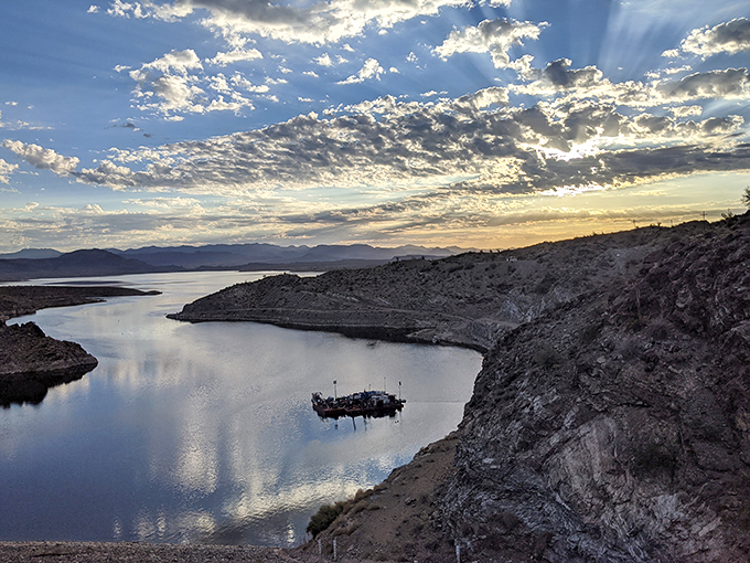 Sunset symphony: As day bids adieu, Alamo Lake transforms into a liquid gold masterpiece framed by nature's own amphitheater.
