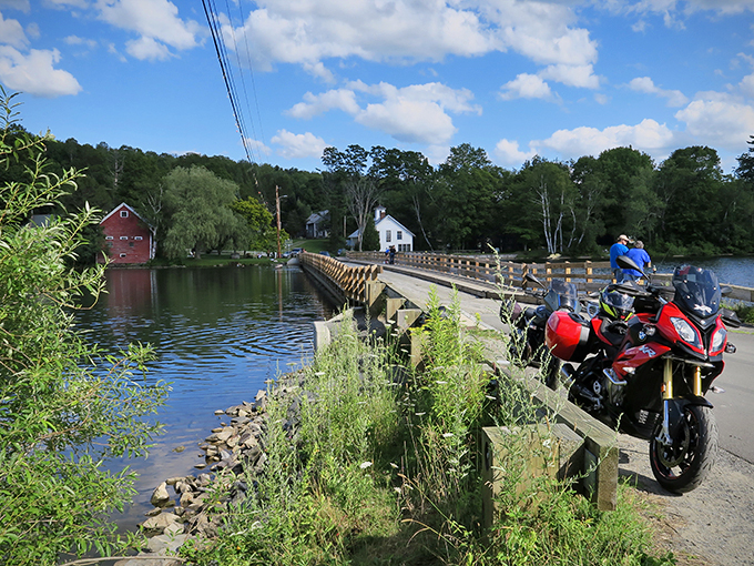This isn't your average Sunday drive - the red motorcycle seems to pause, contemplating its floating journey ahead.