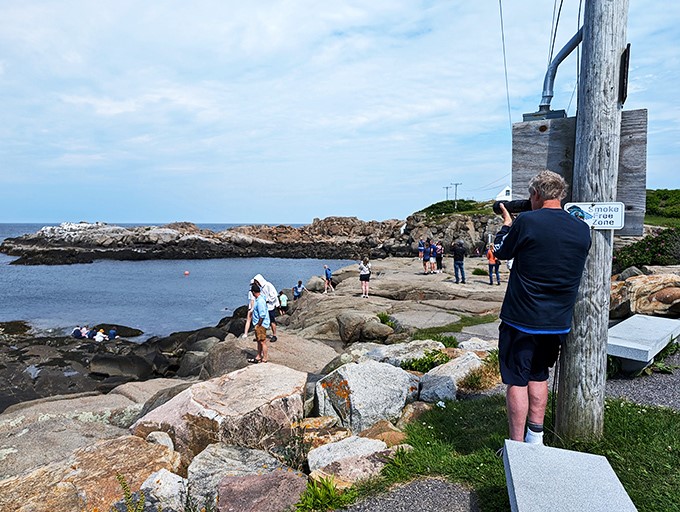Paparazzi, step aside! These folks are capturing memories, not celebrities. Though that lighthouse is quite the star, if you ask me.
