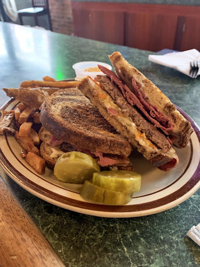 Behold, the Reuben in all its glory! Layers of corned beef, sauerkraut, and melted cheese nestled between grilled rye &ndash; it's a flavor verdict you can sink your teeth into.