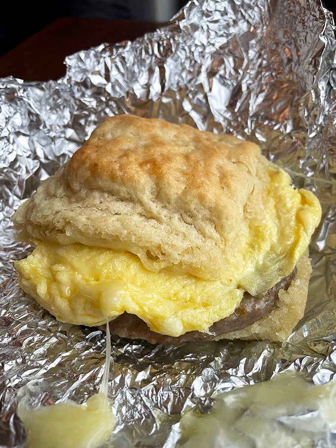 The holy trinity of breakfast: a perfect egg sandwich, golden fries, and a coffee that whispers, "Good morning, gorgeous."