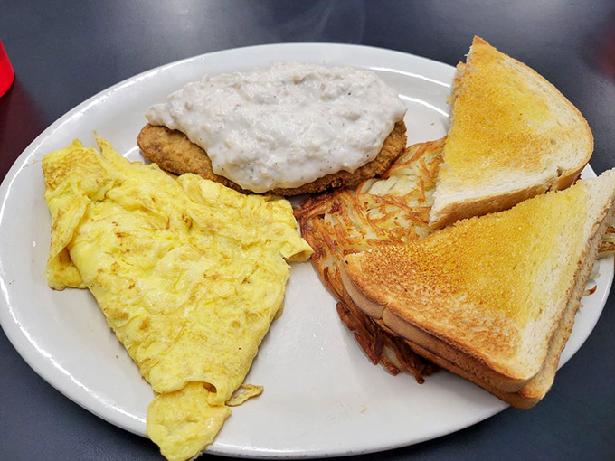 Breakfast perfection on a plate! This chicken fried steak and eggs combo is like a warm hug for your stomach, complete with a side of crispy hash browns and buttery toast.