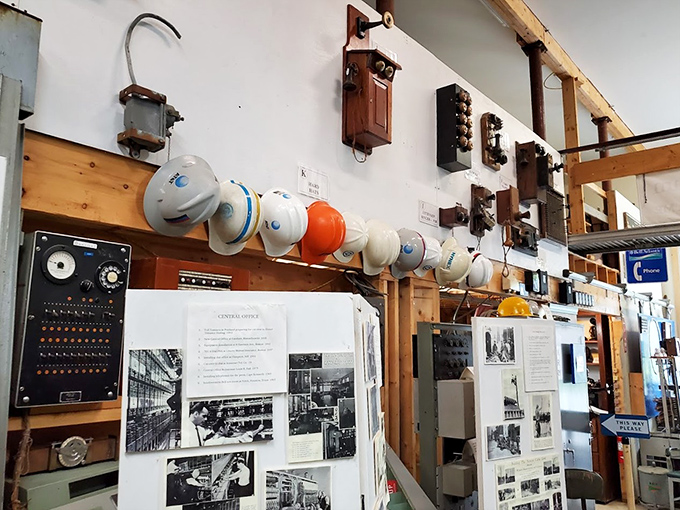 Hard hats line up like soldiers above vintage equipment, telling tales of the workers who kept America connected.