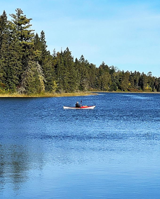 Row, row, row your boat&hellip; or kayak! A lone paddler glides across mirror-like waters, probably humming the theme from "Jaws" for fun.