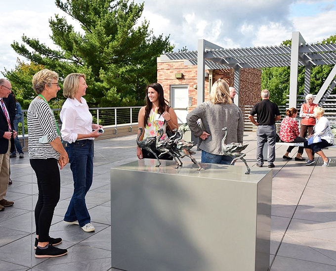 Art in motion! Visitors gather around a sculpture, proving that sometimes the best way to appreciate art is to get up close and personal.