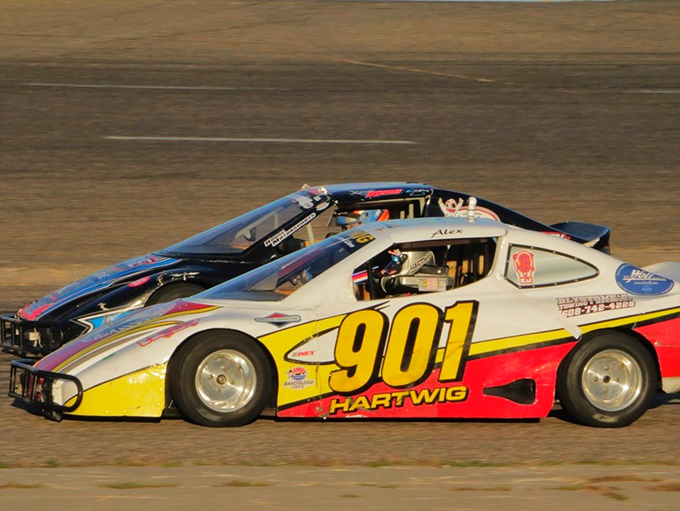 Two cars, one mission: cross that finish line first! It's like watching a high-speed chess match, but with more horsepower.