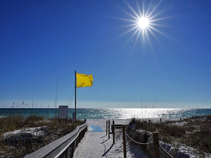 Beach day perfection: A yellow flag waves hello as the sun plays peek-a-boo with cotton candy clouds. Flip-flop paradise awaits!