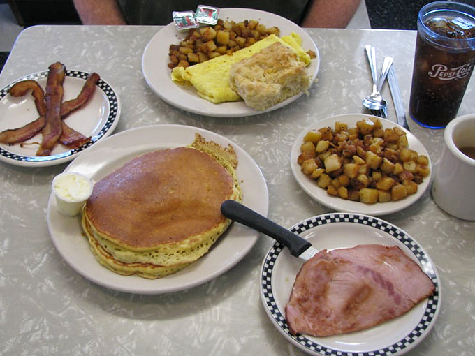 Pancakes as big as frisbees, eggs sunny enough to blind you, and enough bacon to make a cardiologist weep. This isn't breakfast; it's an edible hug.