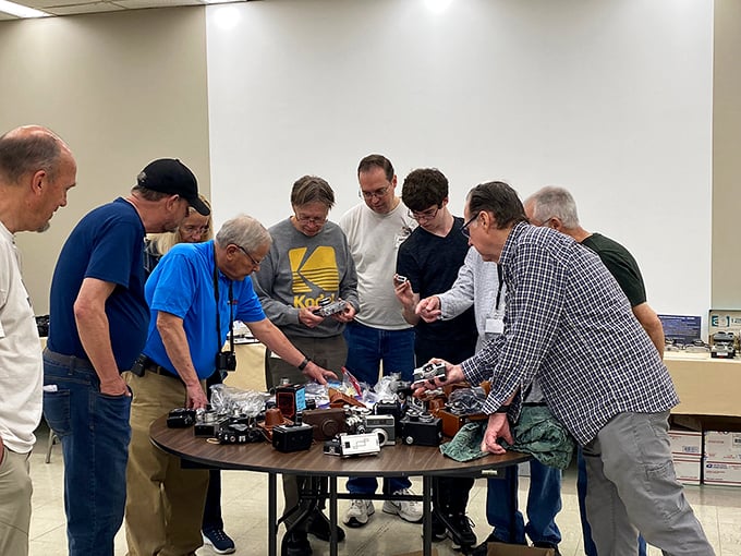 Camera club in session! These folks are so excited about vintage gear, you'd think they just discovered the secret to time travel.