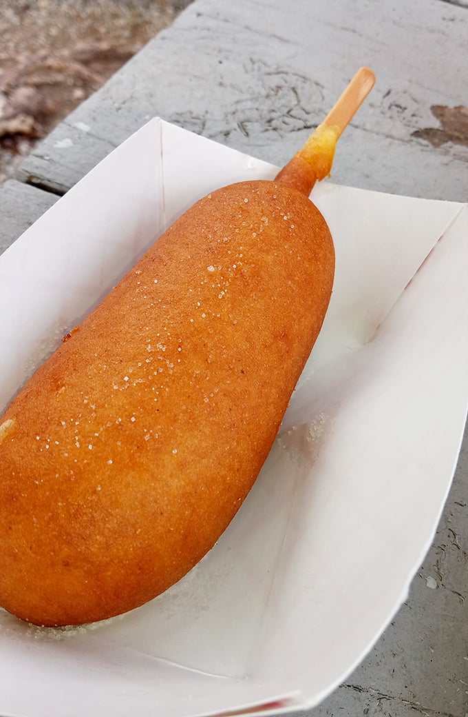 Behold, the golden-fried unicorn of county fairs! This corndog's got more charm than a Southern belle at a cotillion.