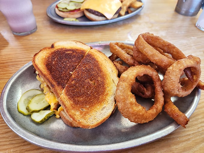 Grilled cheese, meet your cooler cousin. This sandwich is bringing its A-game with golden-brown perfection and a side of crispy onion rings.