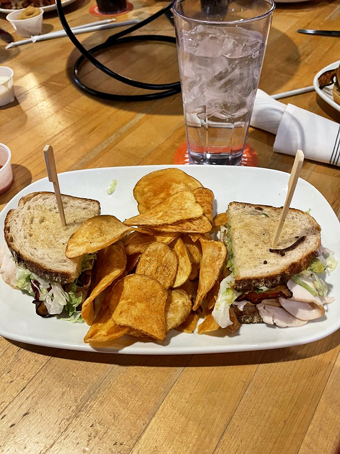 Sandwich game strong! This beauty is stacked higher than a Jenga tower, with crispy chips standing guard. It's a handheld feast that'll make your mouth do a happy dance.