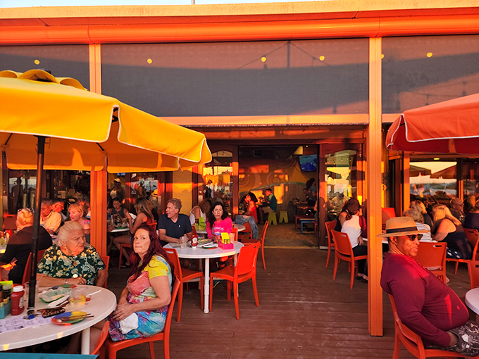 Happy diners soaking up the sunset and good vibes. It's like a beach party where the dress code is "come as you are."