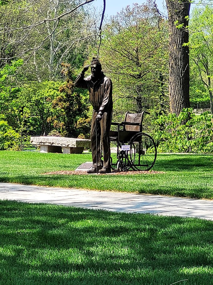 A pensive figure in bronze. This thought-provoking statue invites visitors to pause and reflect amidst nature's beauty.