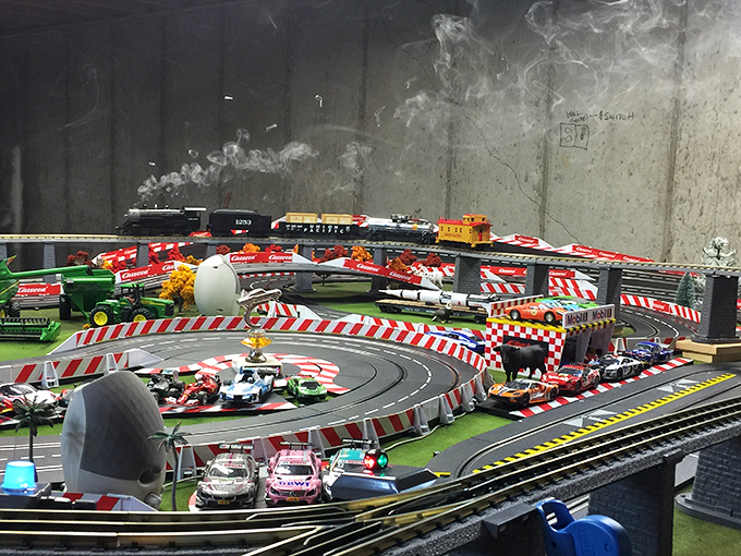Fast and furious, miniature style. This race track display brings the thrill of the speedway to the world of model trains.