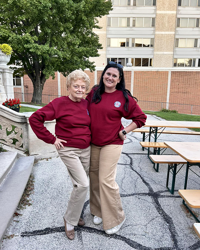 Cheerful staff in matching red sweatshirts standing outside, posing as if they're in a cover of Vogue.