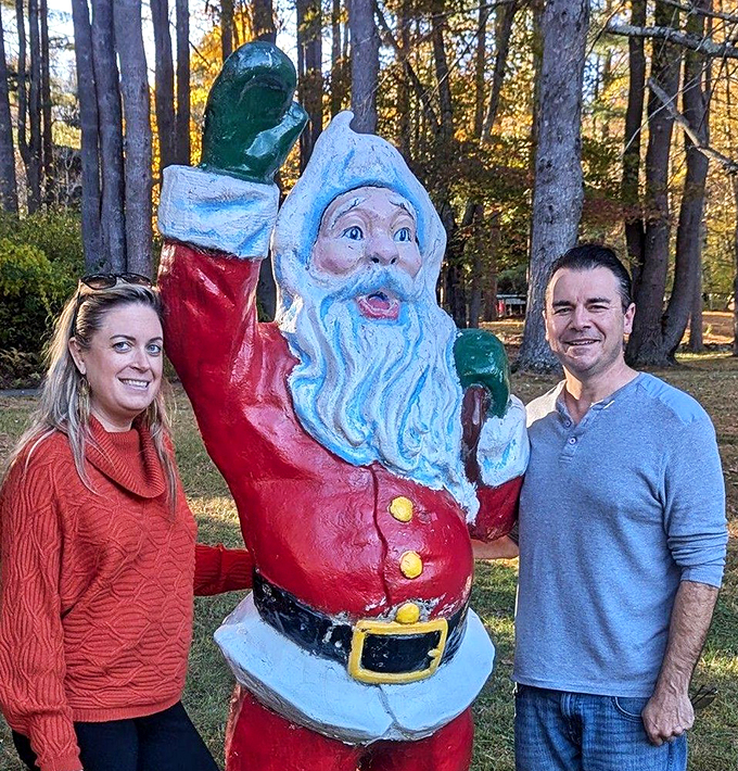 Say "Christmas cookies!" Visitors pose with a jolly Santa statue, proving you're never too old for a holiday photo op.