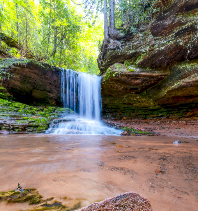 Those layered sandstone walls framing the waterfall create a natural gallery that makes every visitor feel like an art critic.